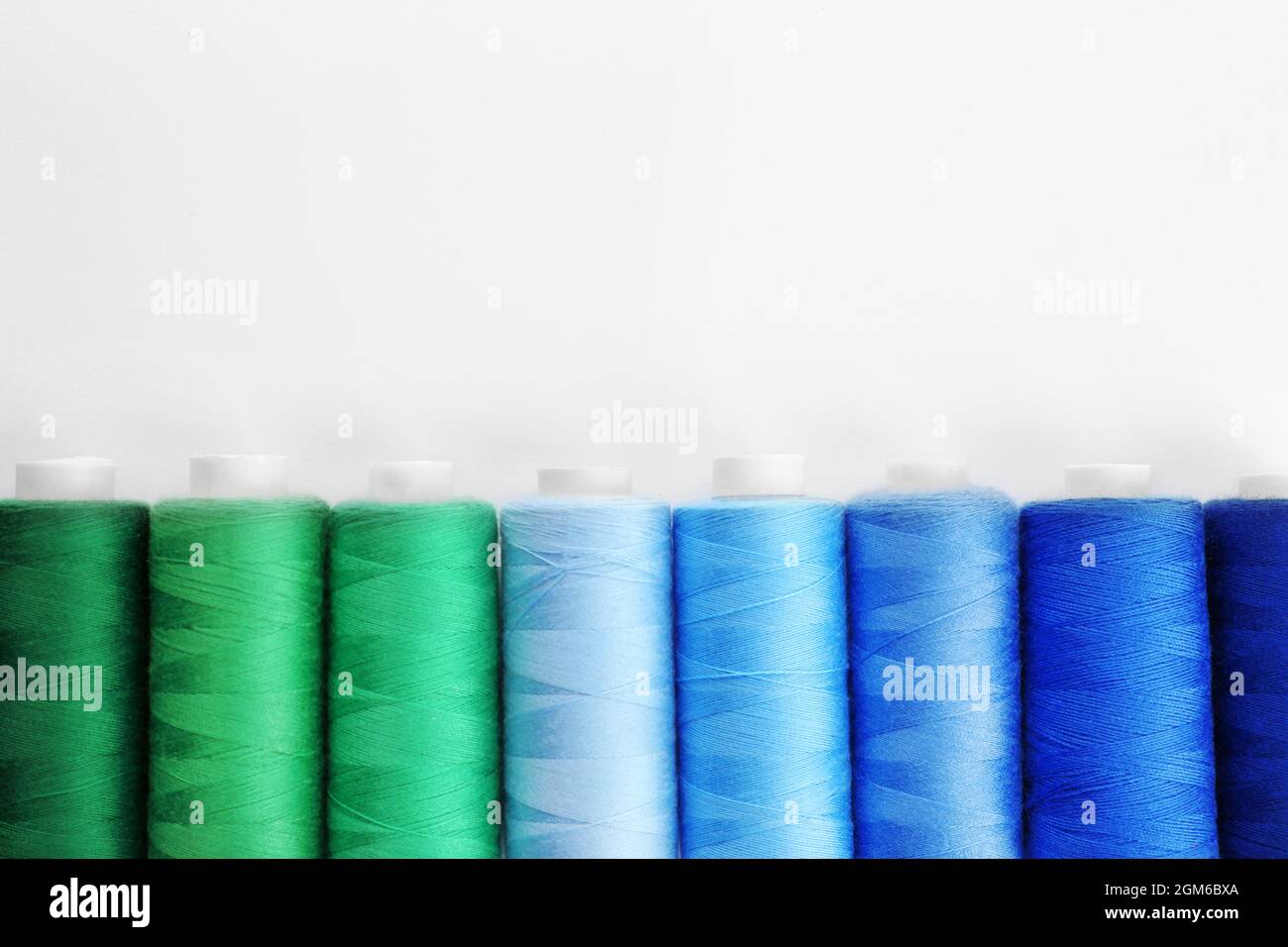 Colorful sewing threads on white background Stock Photo - Alamy