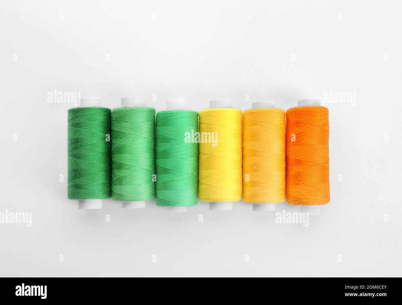 Colorful sewing threads on white background Stock Photo - Alamy
