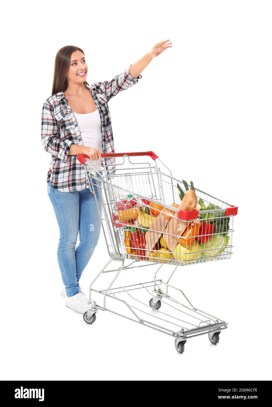Young woman with full shopping cart on white background Stock Photo - Alamy
