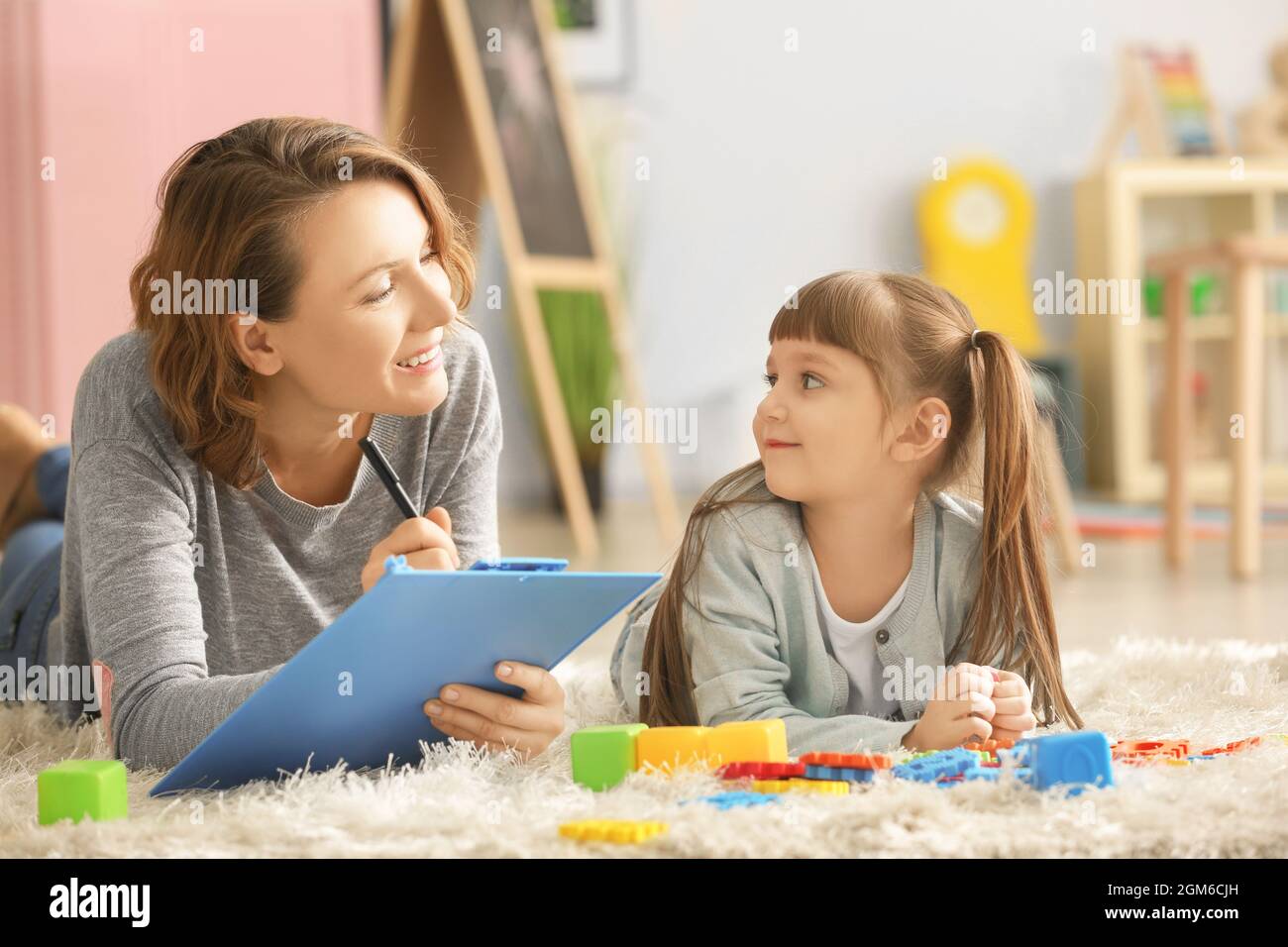 Female psychologist with cute little girl during play therapy Stock ...