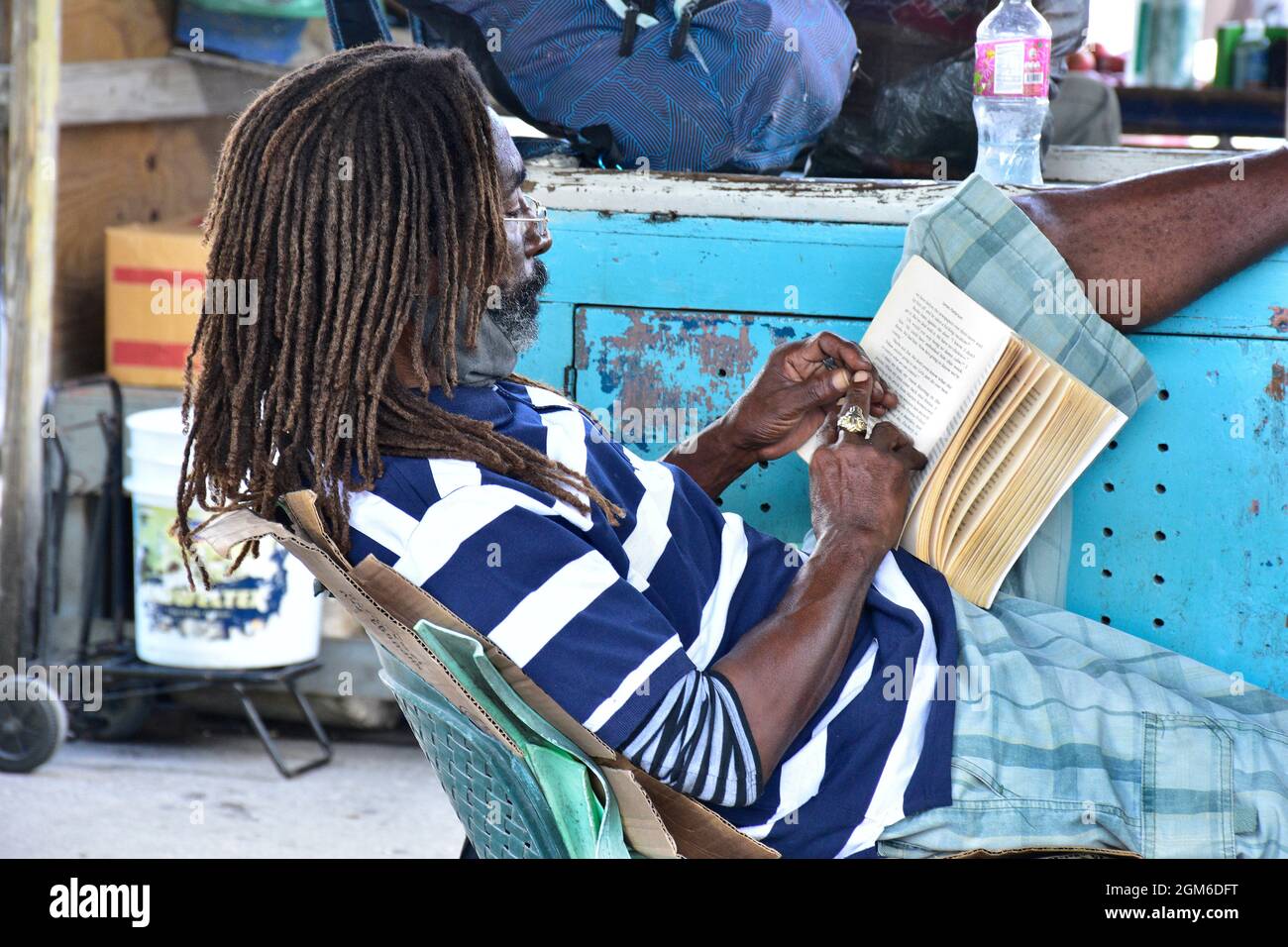 Man Relaxing and reading a book in Bridgetown Barbados Stock Photo - Alamy