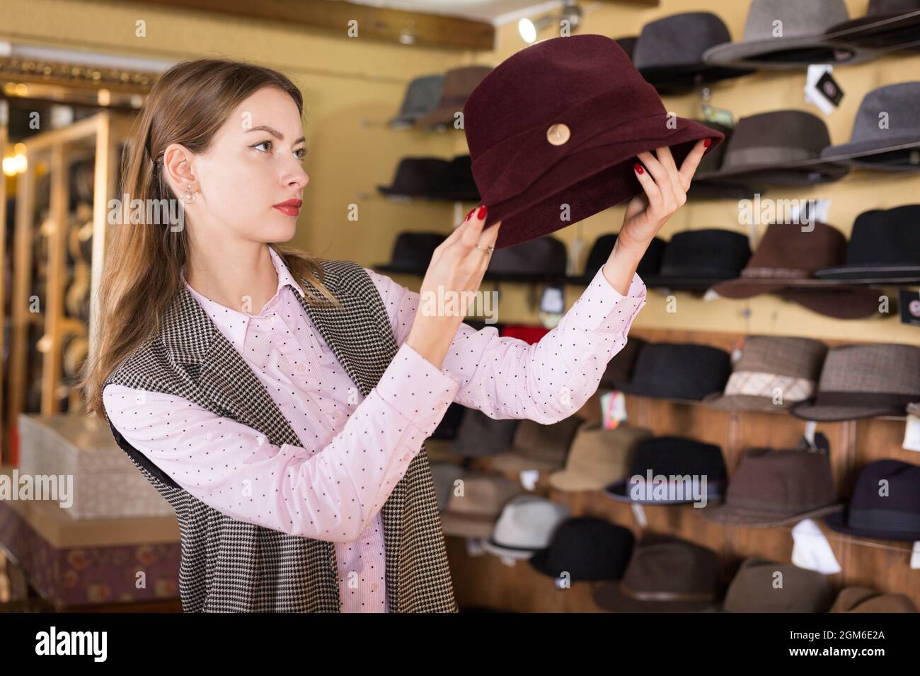 Woman choosing hat in store Stock Photo - Alamy