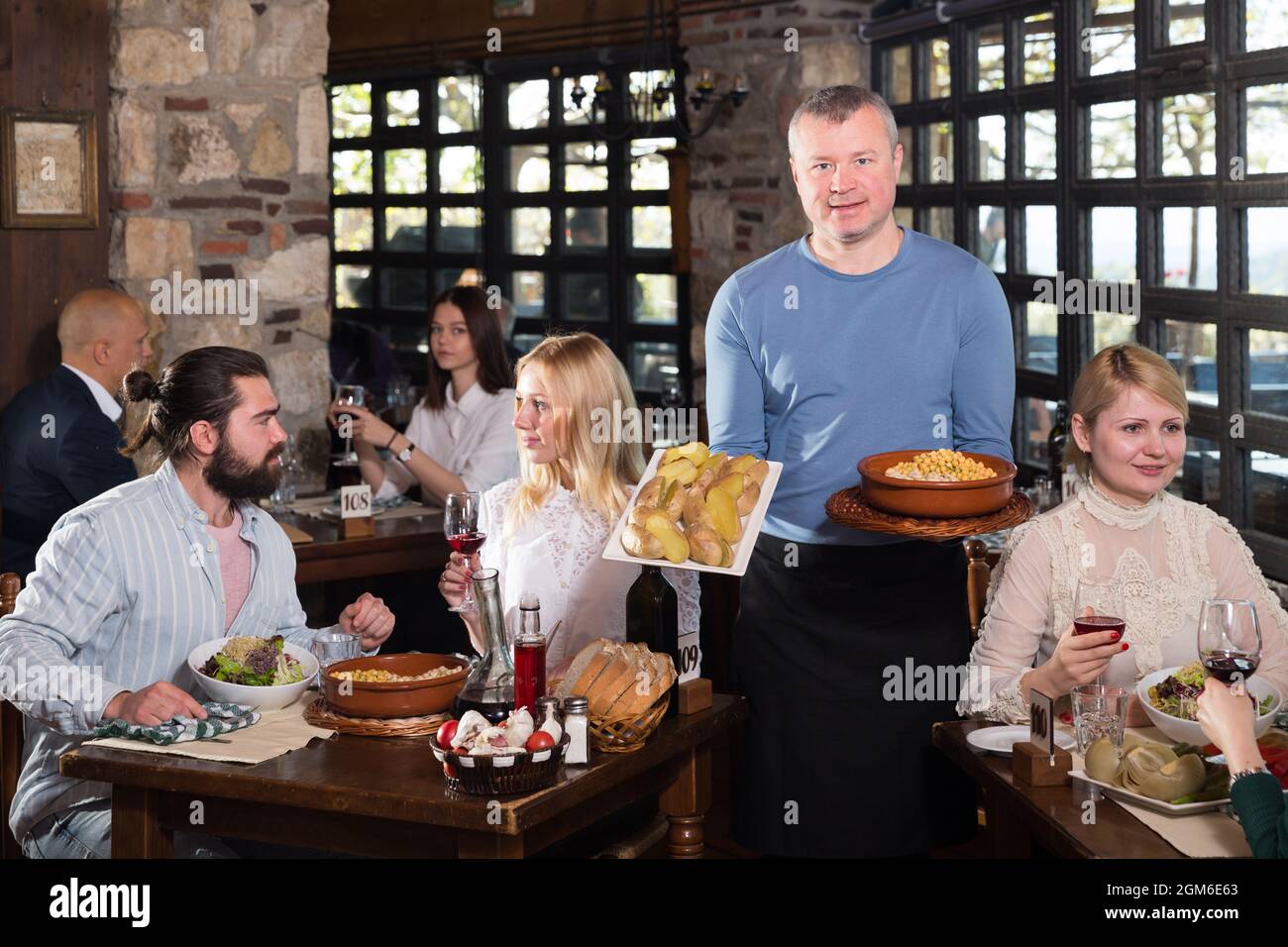 Country restaurant owner with traditional meals Stock Photo - Alamy