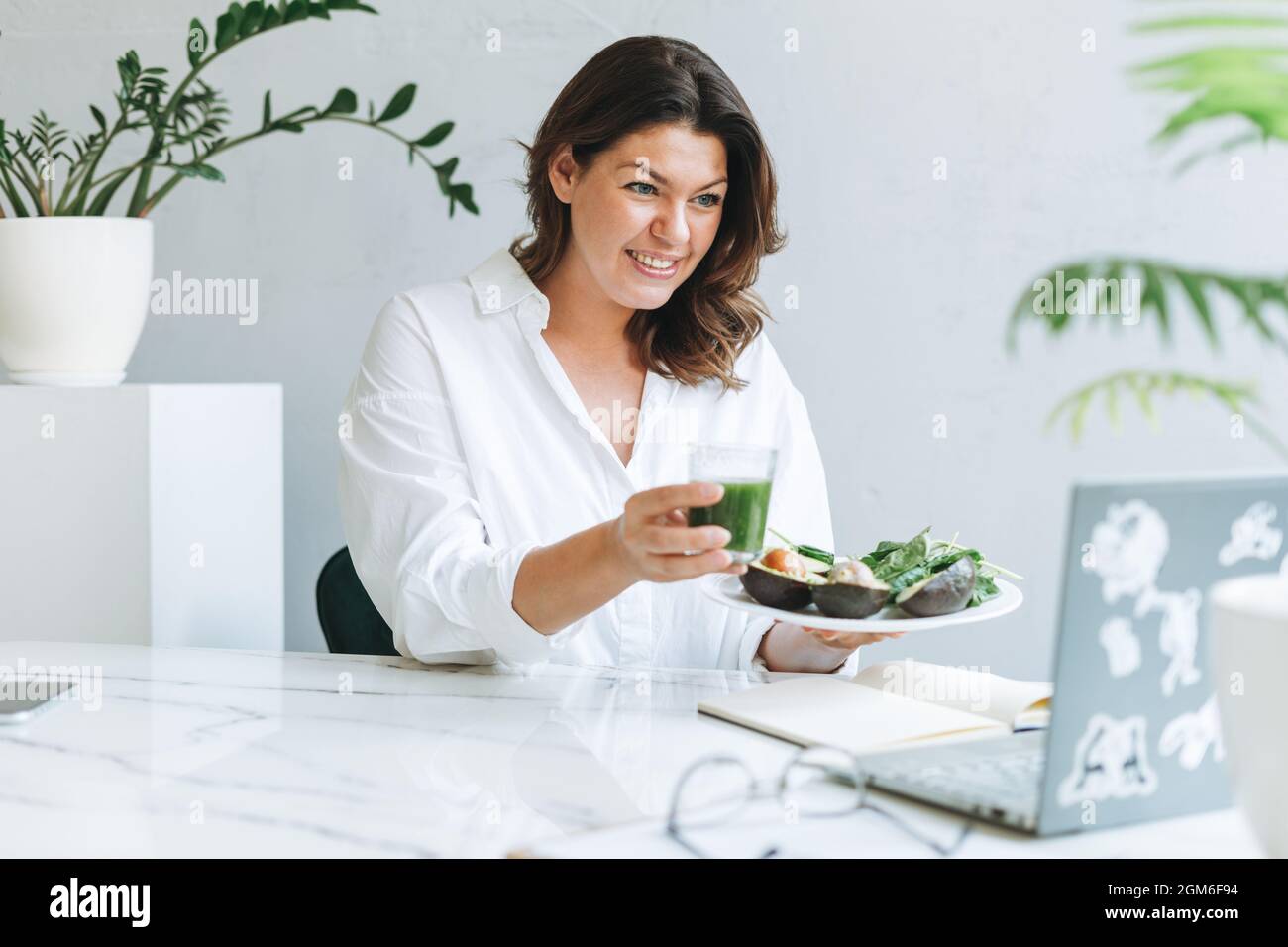 Young smiling brunette woman nutritionist doctor plus size in white ...