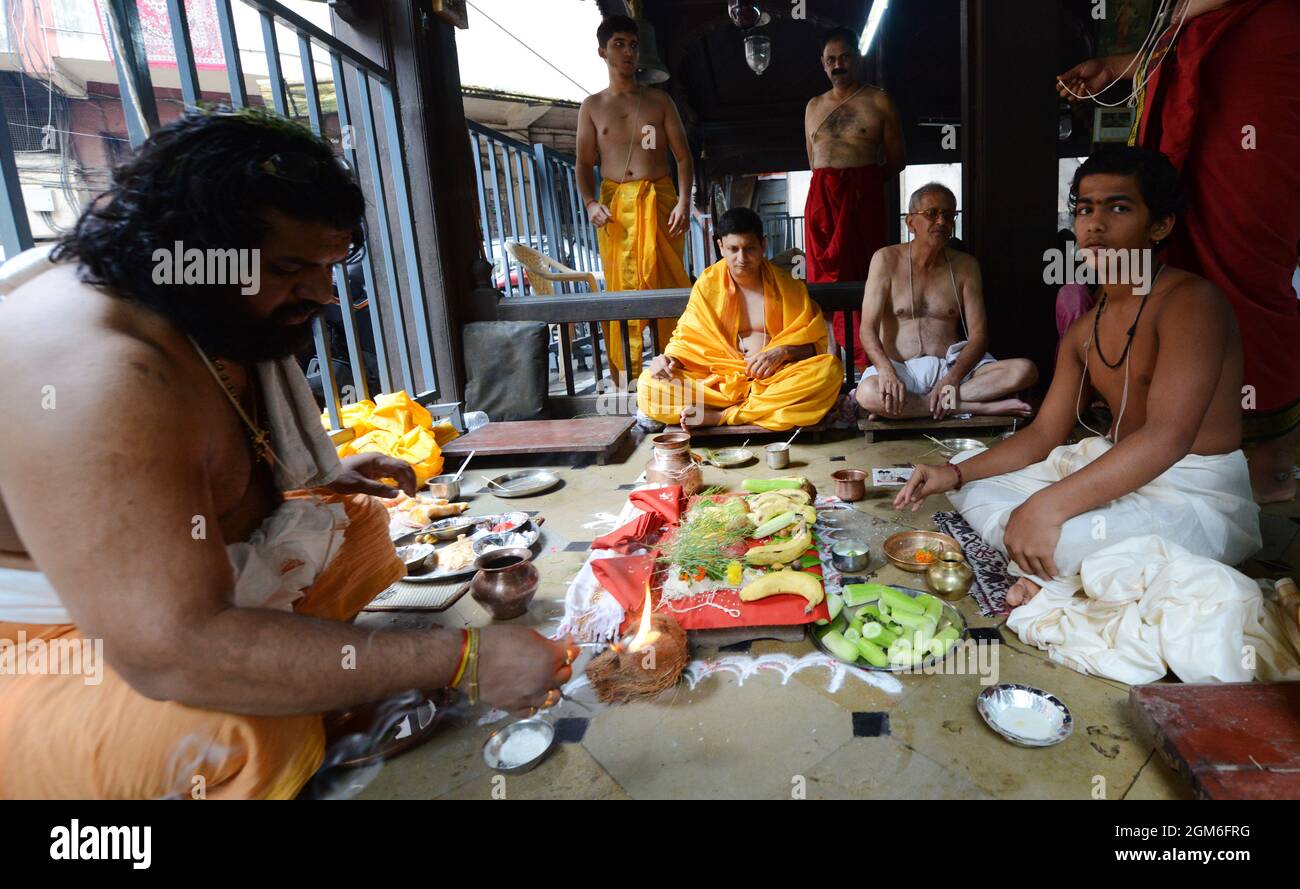 Marathi Hindu priests conducting a religious ceremony in a small temple ...