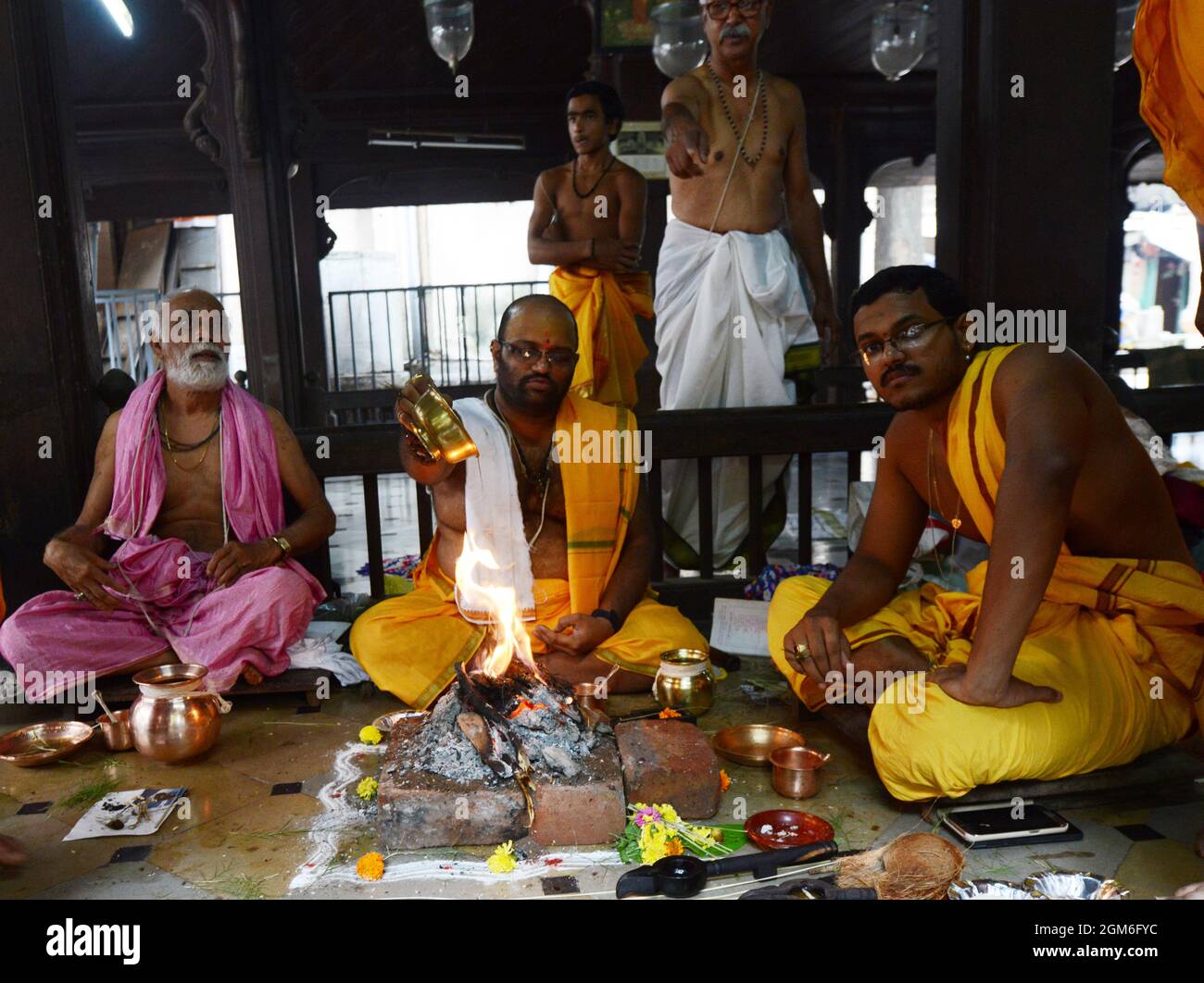 Marathi Hindu priests conducting a religious ceremony in a small temple ...