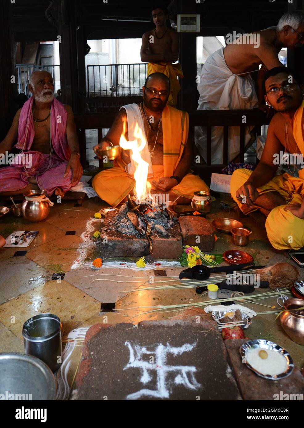 Marathi Hindu priests conducting a religious ceremony in a small temple ...