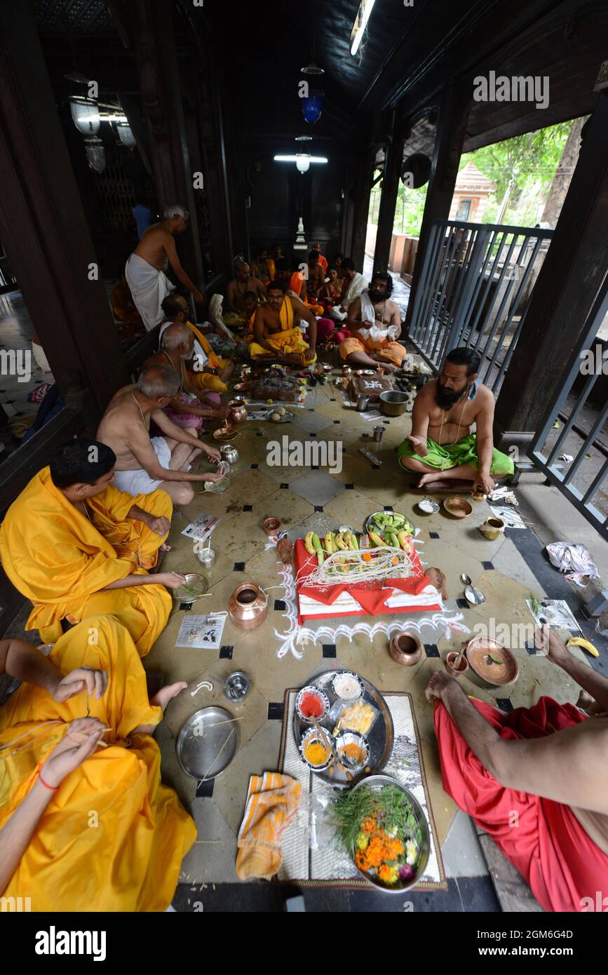 Marathi Hindu priests conducting a religious ceremony in a small temple ...