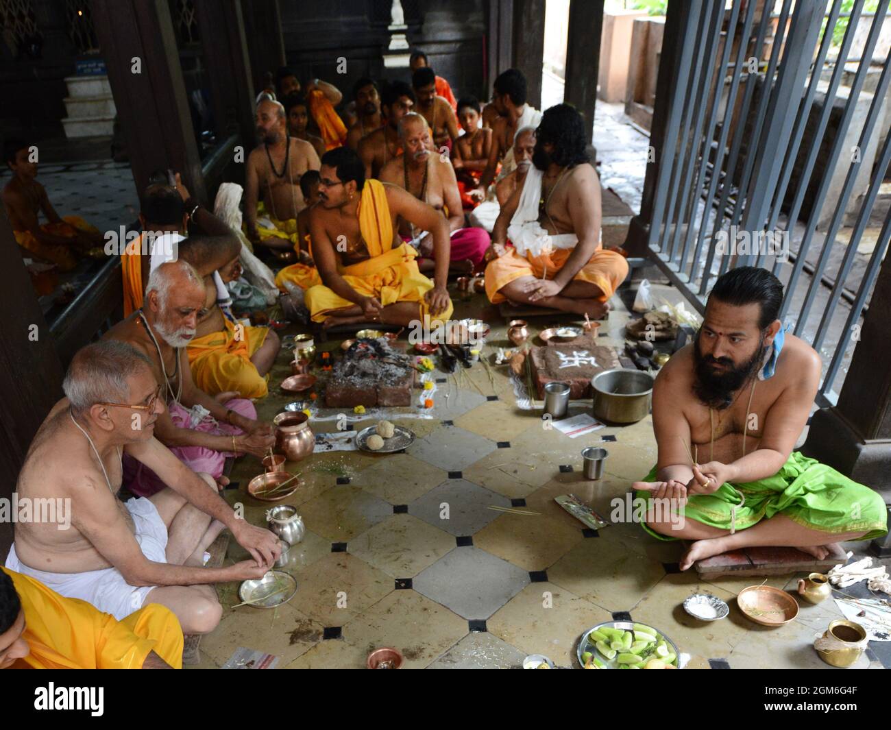 Marathi Hindu priests conducting a religious ceremony in a small temple ...