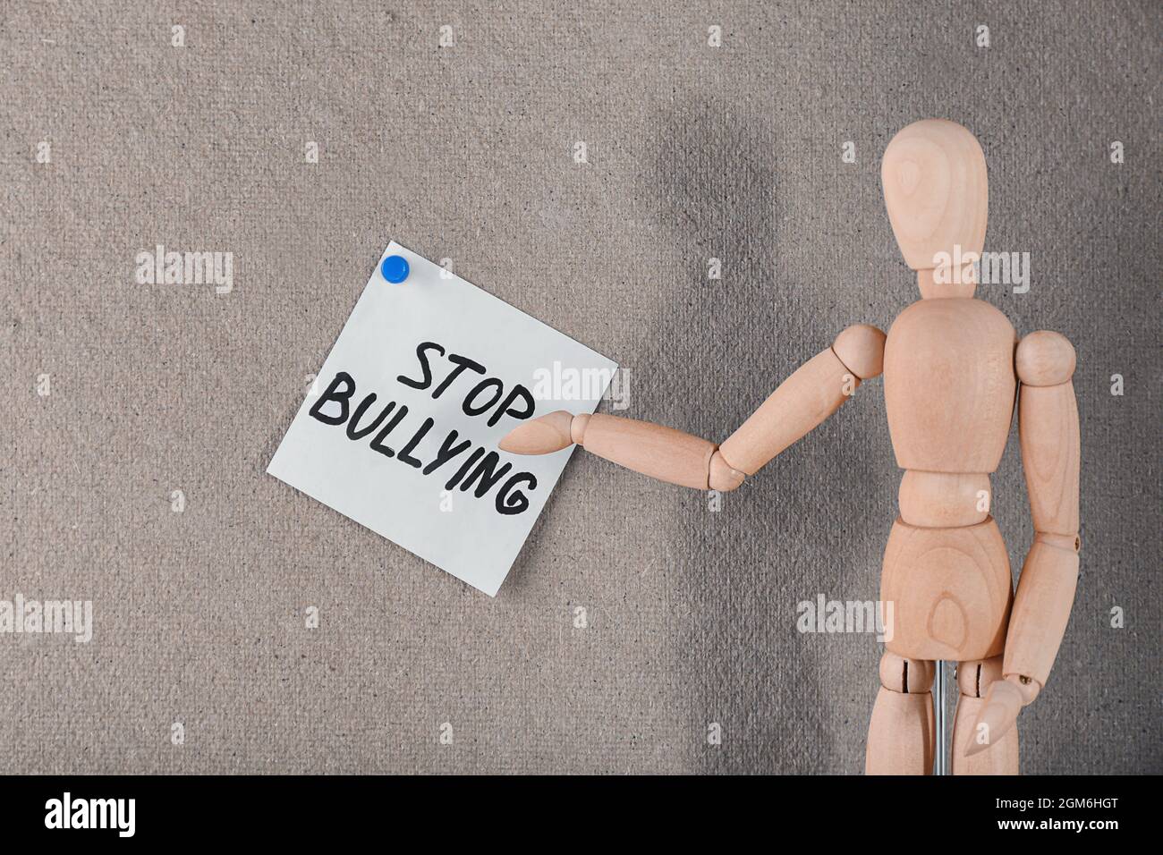 Wooden figure and note with text "Stop bullying" on grey background ...