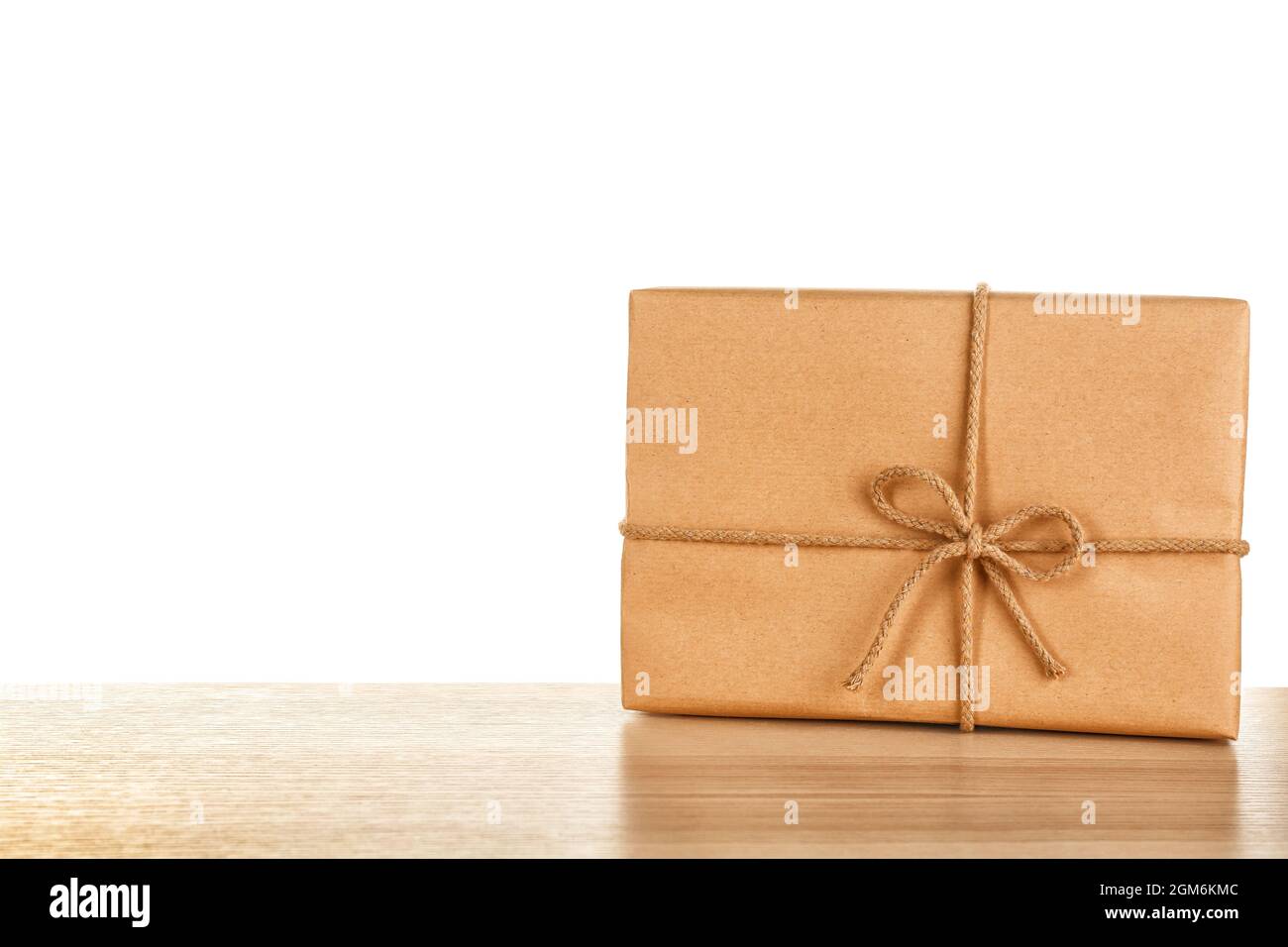 Parcel gift box on table against white background Stock Photo - Alamy