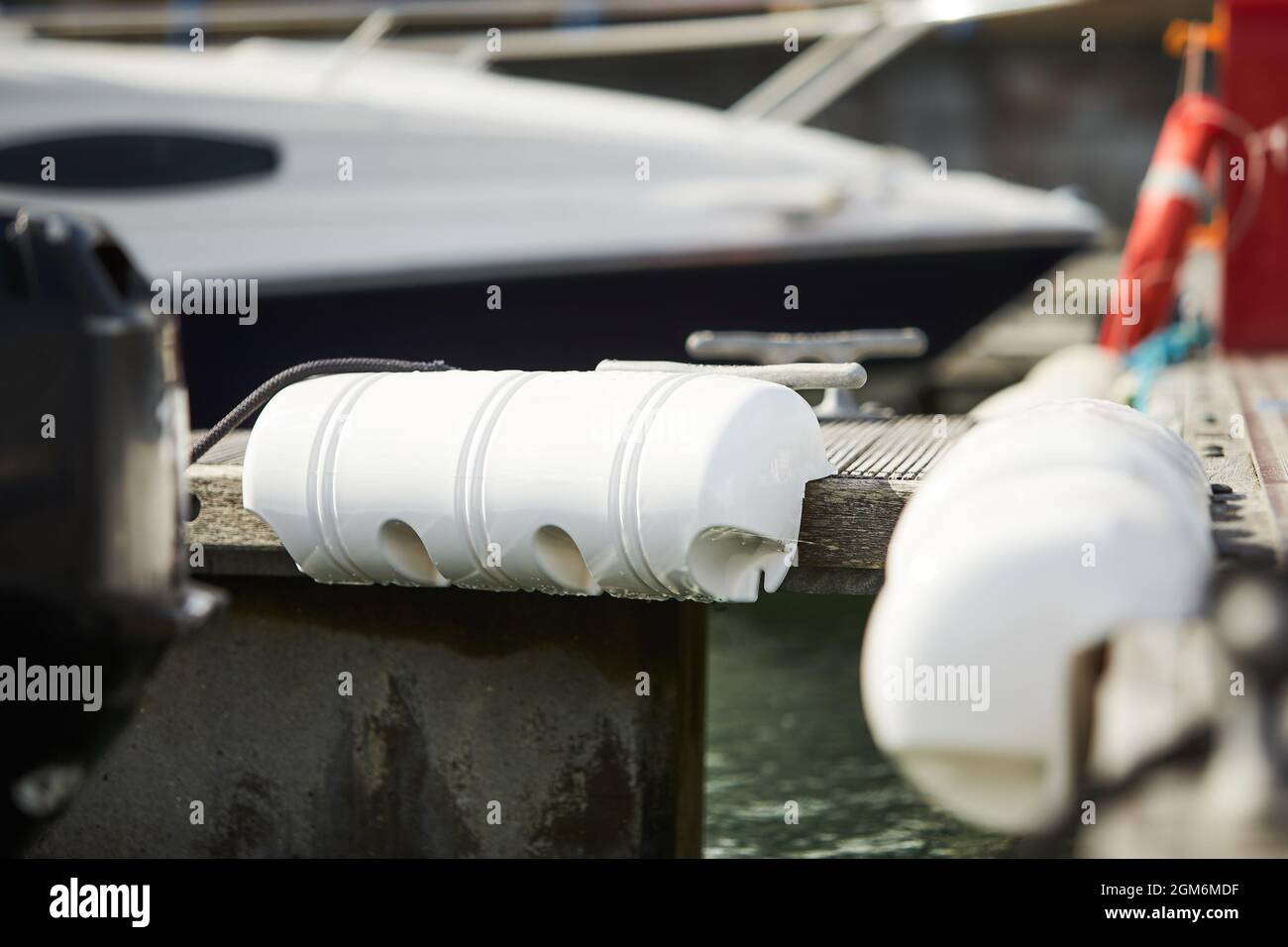 Long pier white fenders for a boat and dockside for protection ...