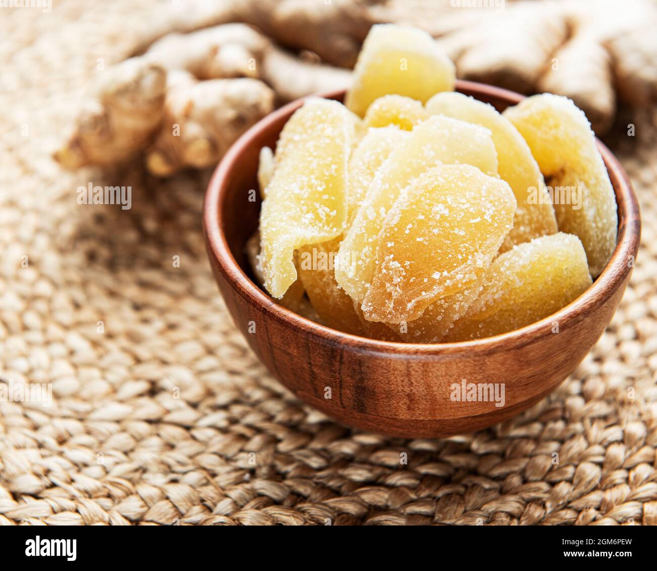 Sweet and spicy candied ginger on a old straw mat background Stock ...