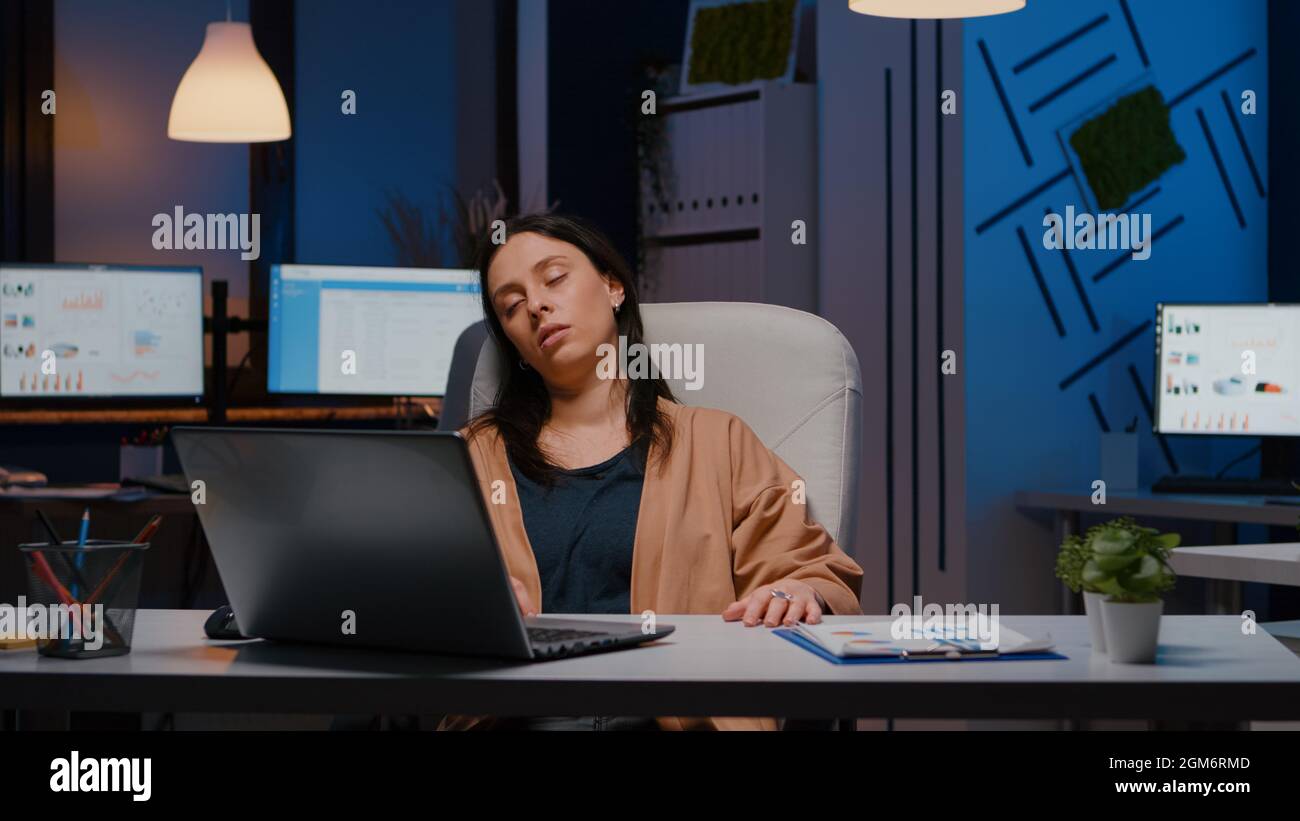 Exhausted entrepreneur woman sleeping in front of laptop while ...