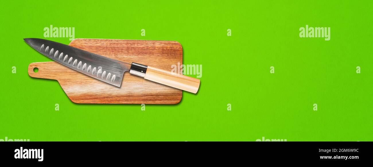 Traditional Japanese gyuto chief knife on a cutting board. green banner ...