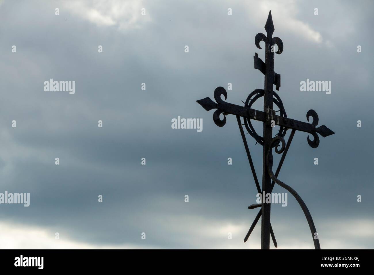ancient iron Christian cross with a gray sky in the background. The ...