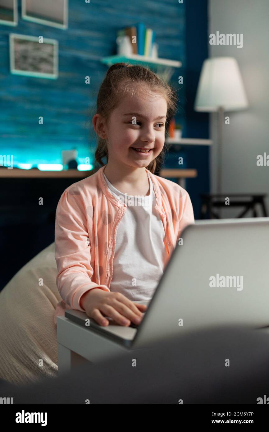 Clever smiling schoolkid working at literature homework browsing ...