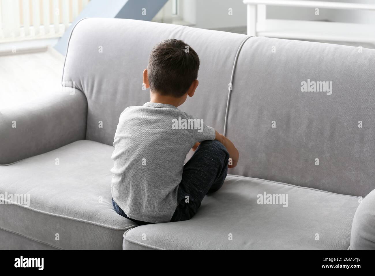 Little boy sitting on sofa at home. Child autism Stock Photo - Alamy
