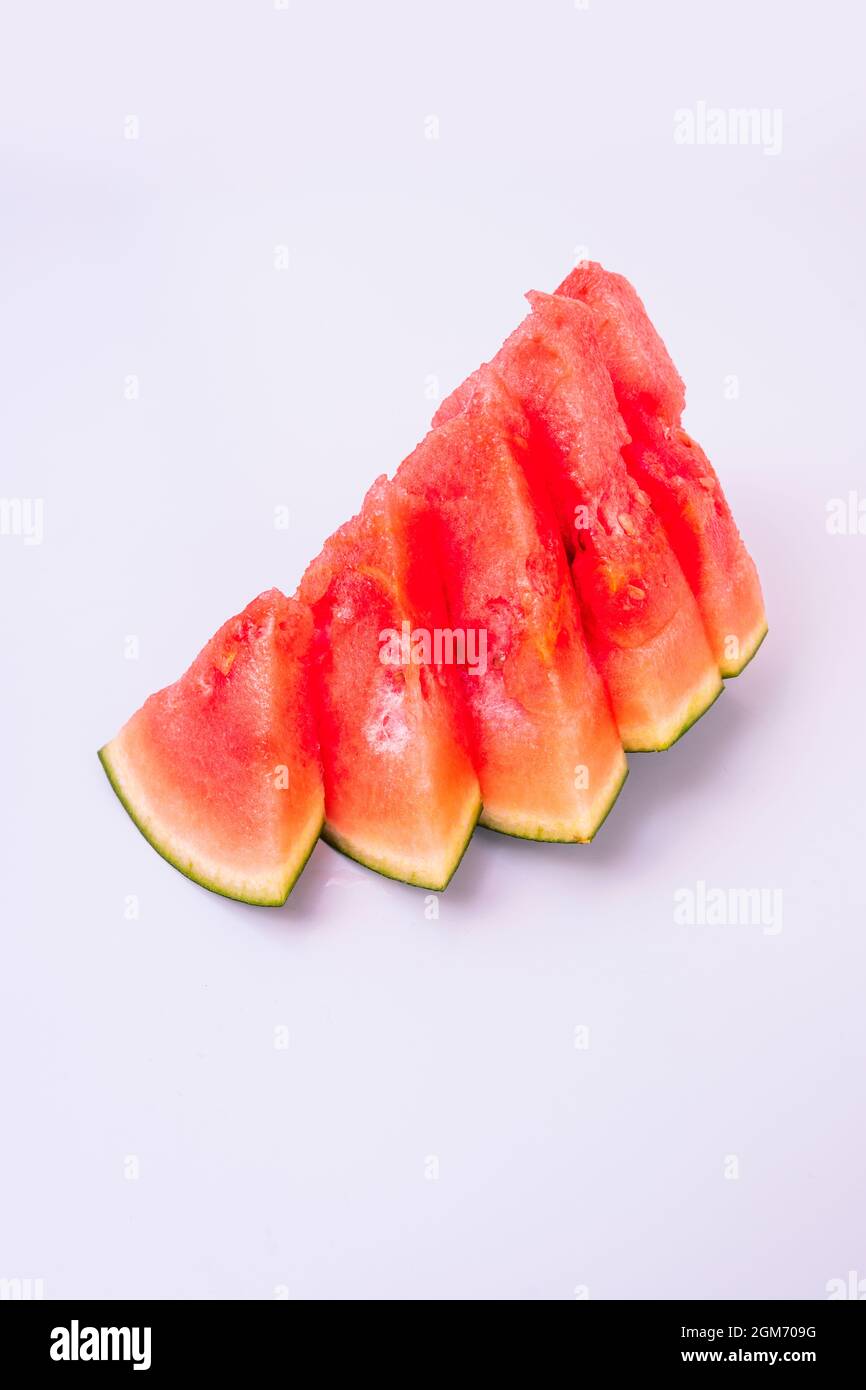 Ragged pieces of red seedless watermelon on pastel gray background ...