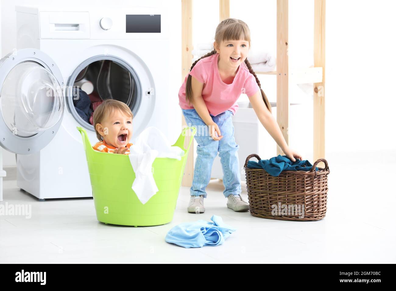 Cute children doing laundry indoors Stock Photo - Alamy