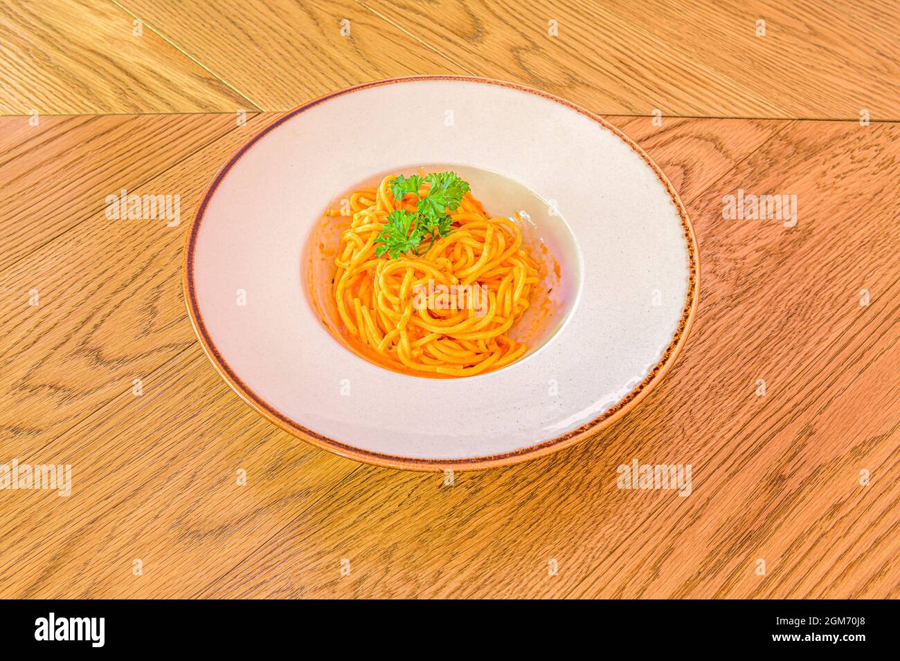 Round white plate with Neapolitan spaghetti with parsley on top on ...