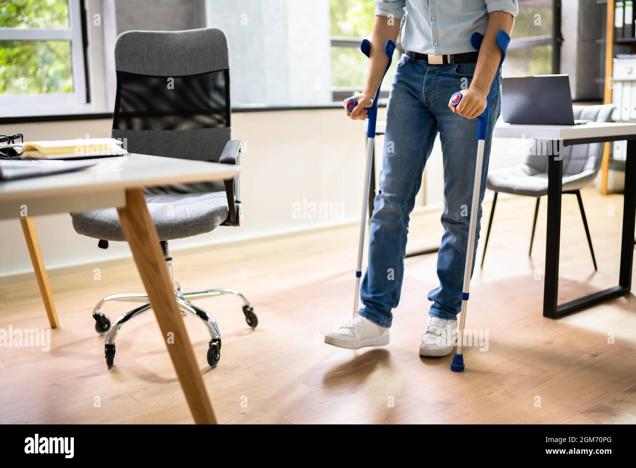 Worker With Crutches At Workplace Or Office. Handicap Rehabilitation ...