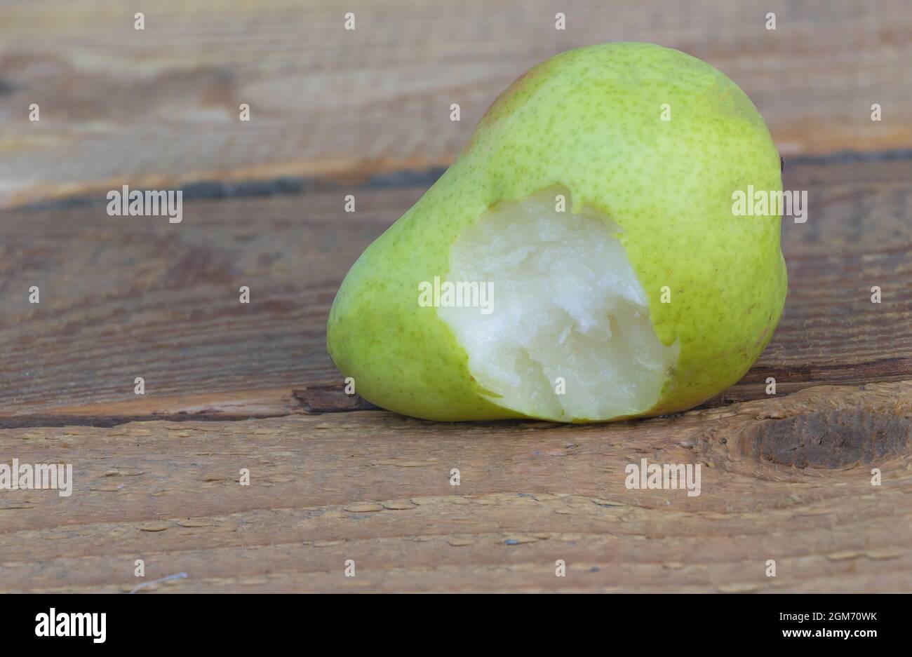 A pear fruit eaten on a wooden background close up Stock Photo - Alamy