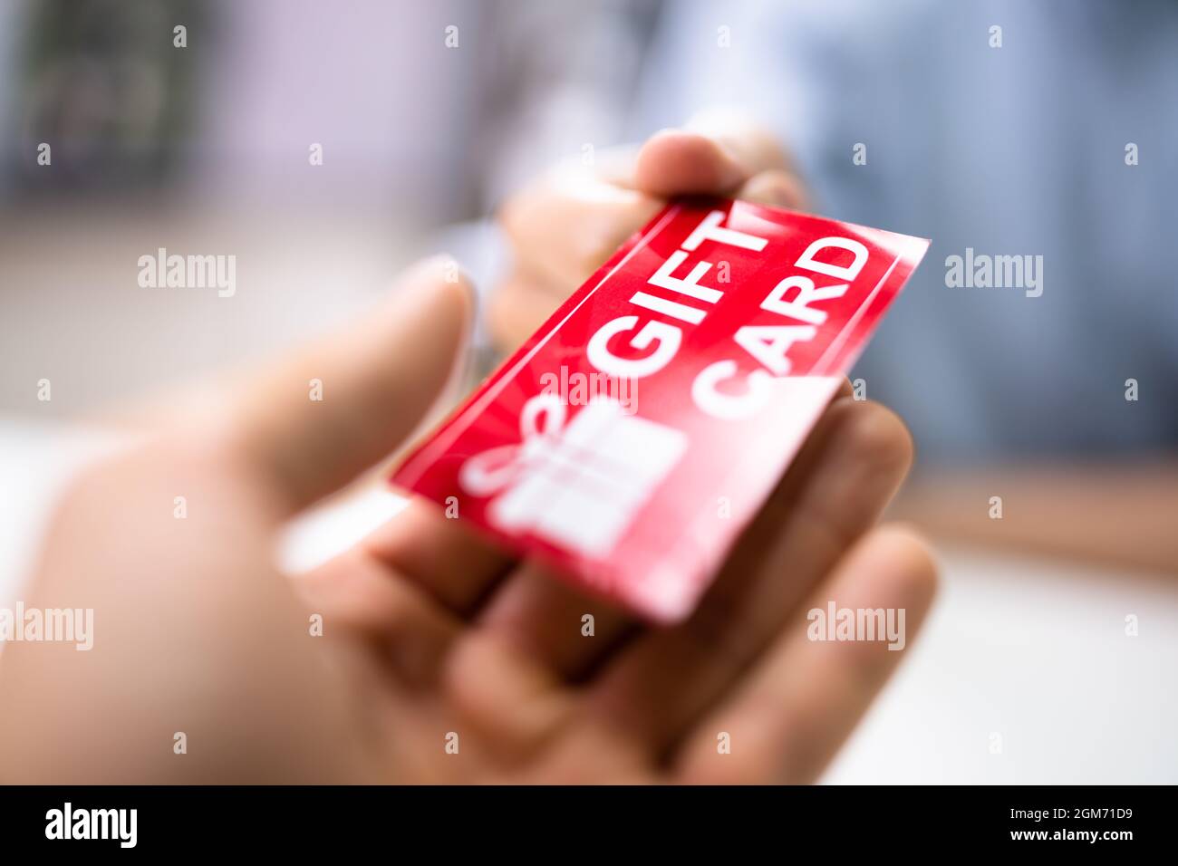 Hand Giving Gift Voucher Card. Holding Prepaid Coupon Stock Photo - Alamy