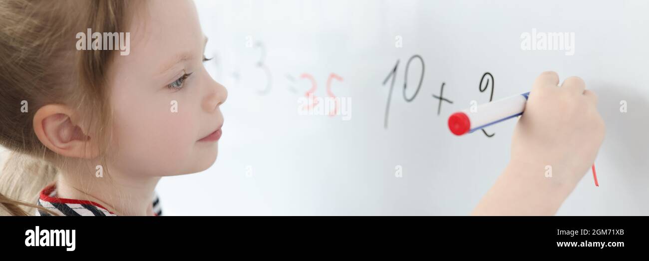 Little girl solving math examples on blackboard Stock Photo - Alamy