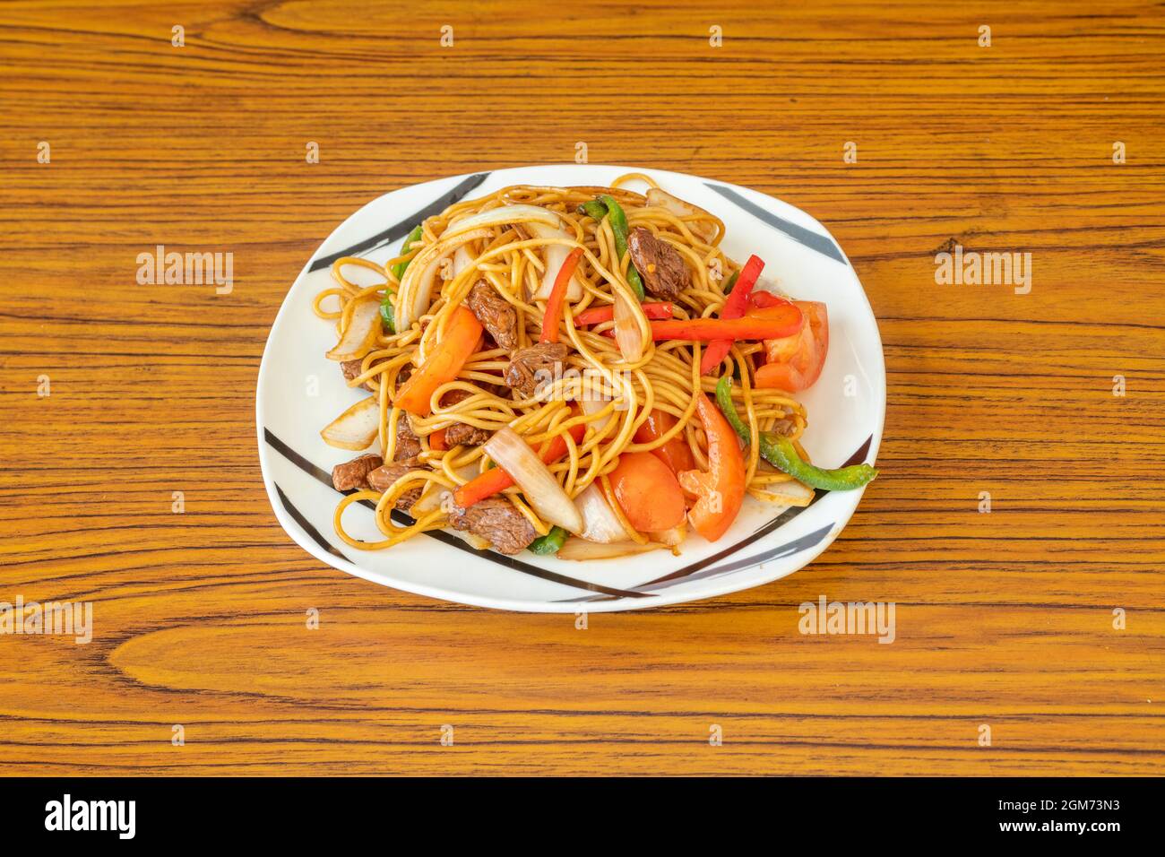 Peruvian recipe of sautéed noodles with beef tenderloin, diced tomatoes ...