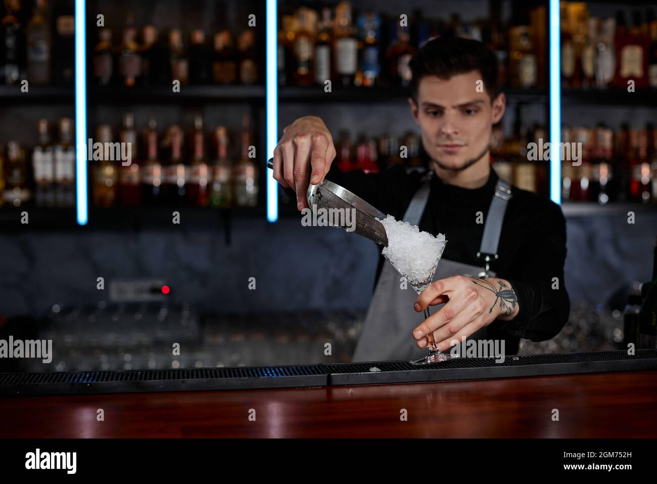 Barman puts the ice cubes into a glass Stock Photo - Alamy