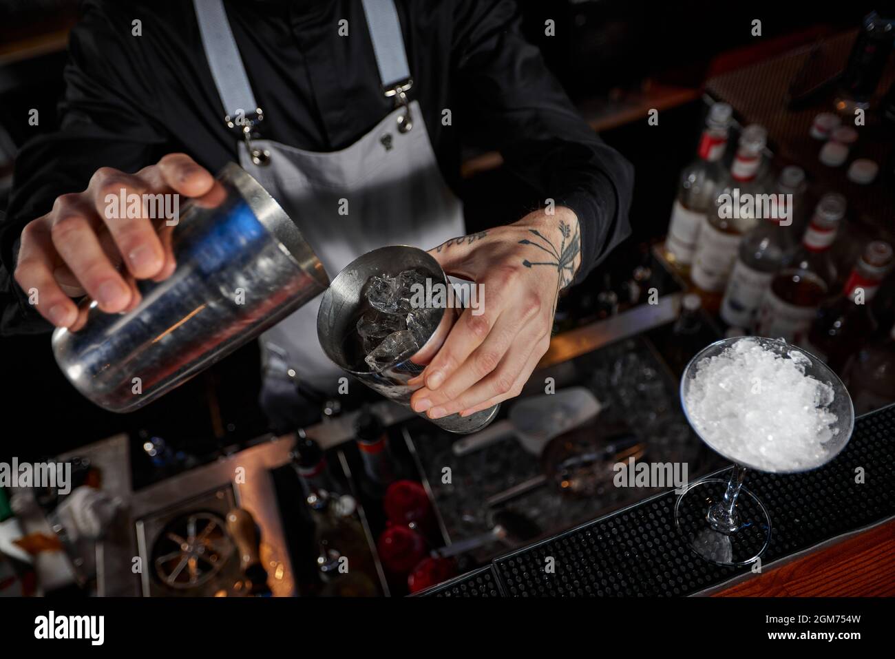 barman is making cocktail with steel shaker Stock Photo - Alamy
