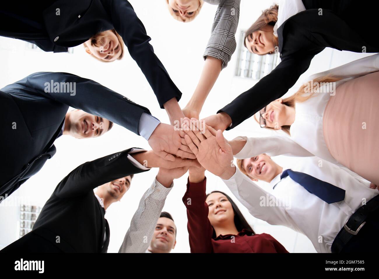 People putting hands together in office. Unity concept Stock Photo - Alamy