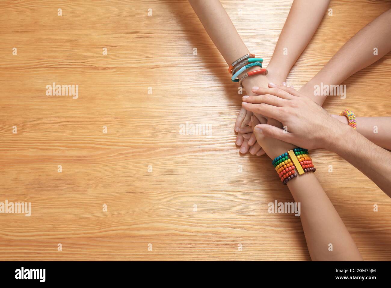 People putting hands together at wooden table as symbol of unity Stock ...