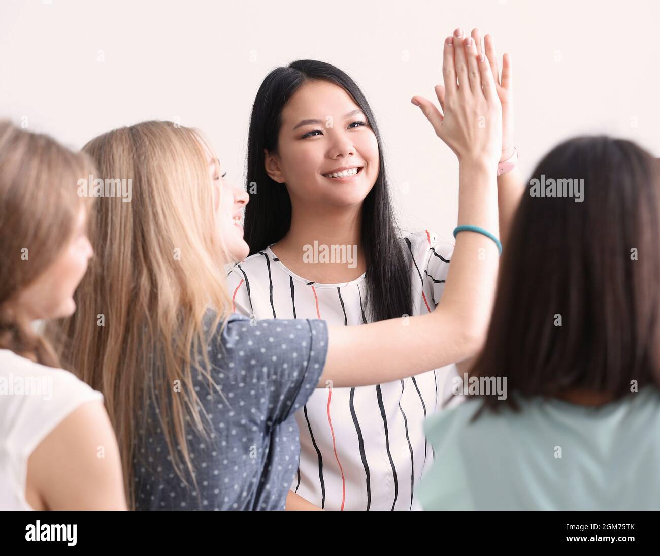 Women giving high five indoors. Unity concept Stock Photo - Alamy