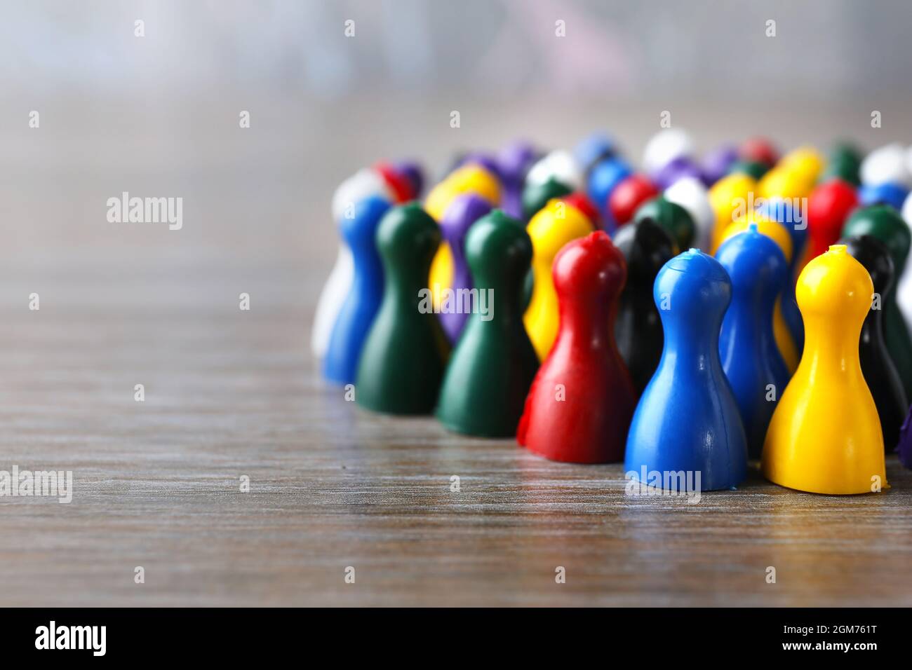 Group of color pawns on wooden table. Unity concept Stock Photo - Alamy