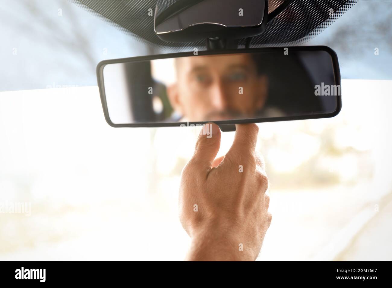 Man adjusting rear view mirror in car Stock Photo - Alamy