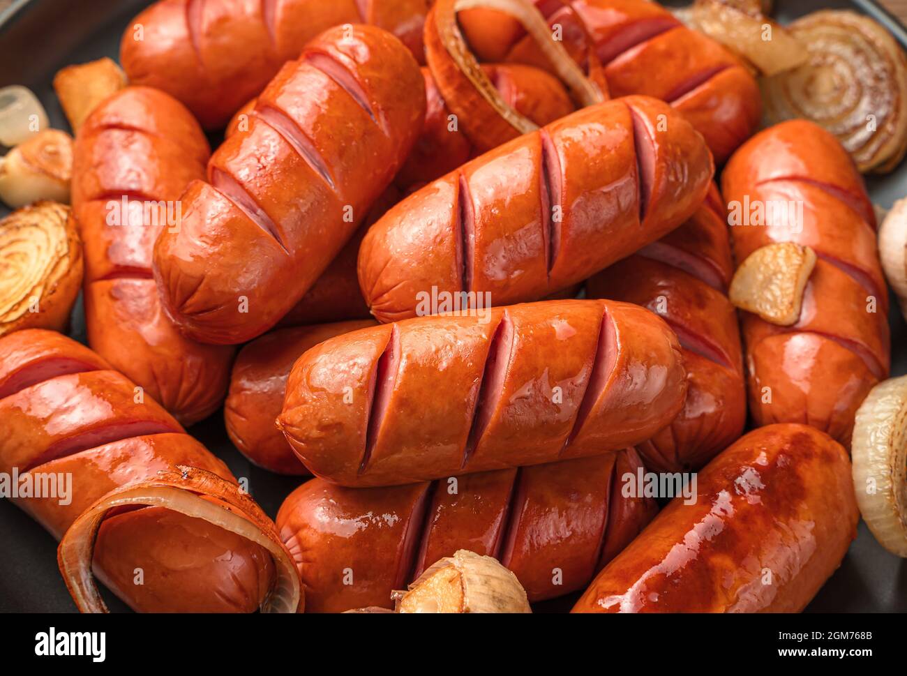 Sausages with onions and garlic close-up. Side view, horizontal. Fast ...