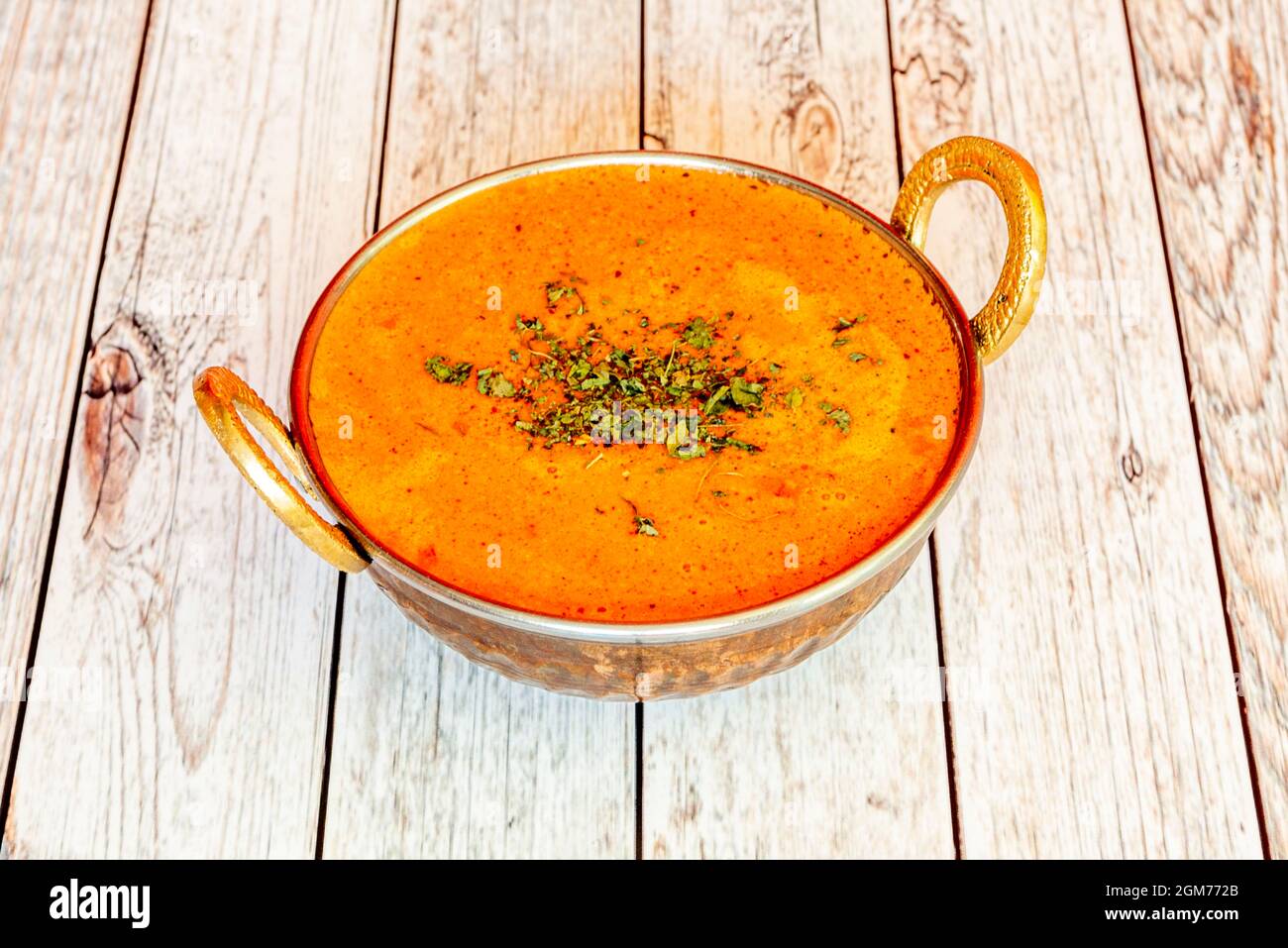 Chicken tikka masala served in a traditional metal bowl of a Pakistani ...