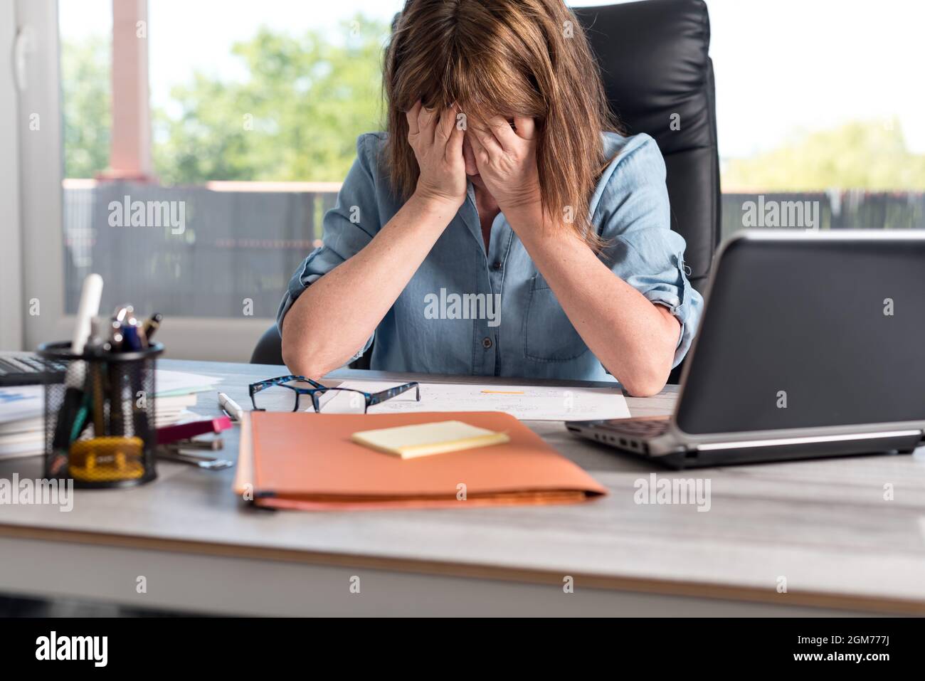 Portrait of overworked businesswoman sitting in office Stock Photo - Alamy