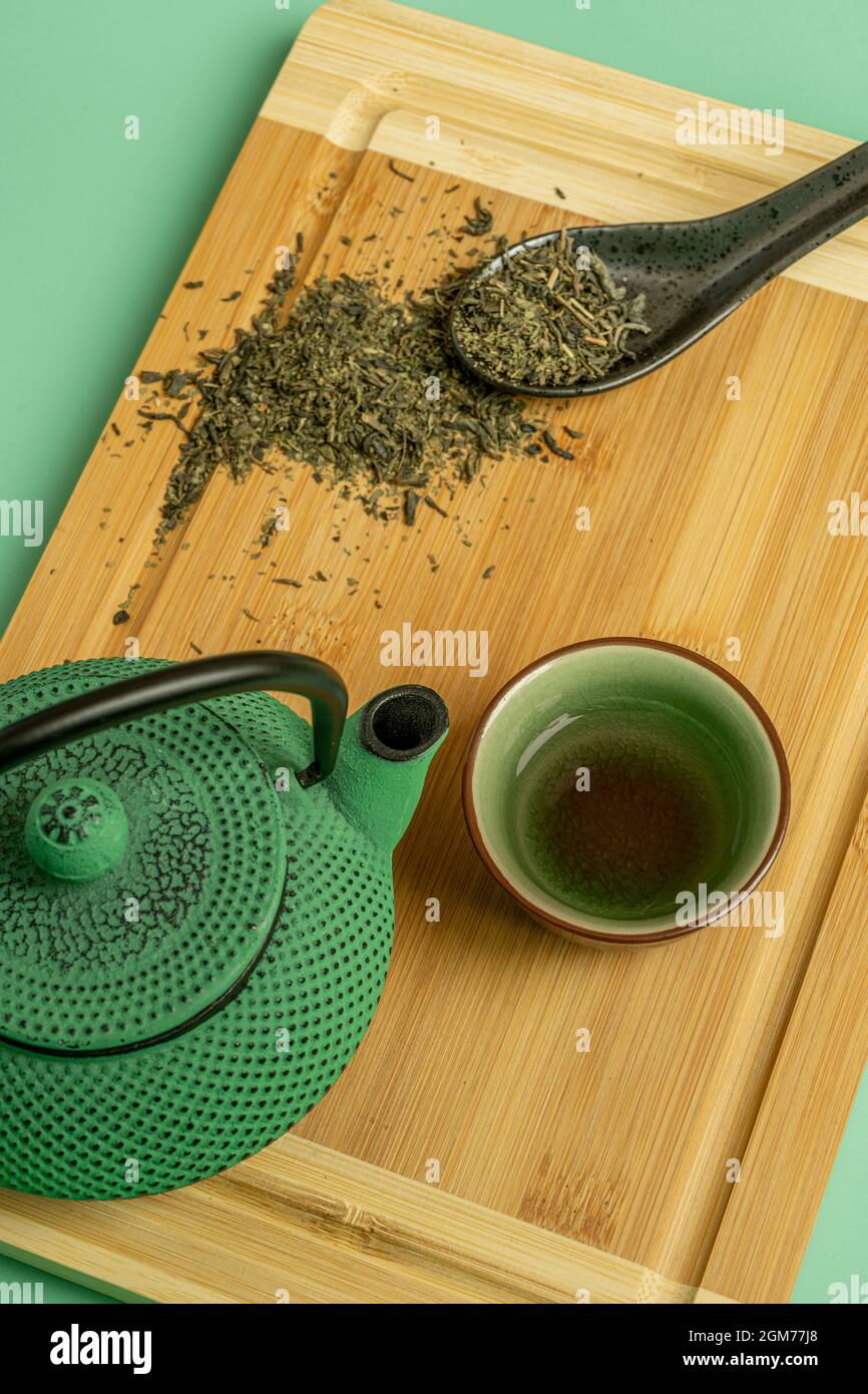 Top view image of traditional green tea set and black porcelain spoon ...
