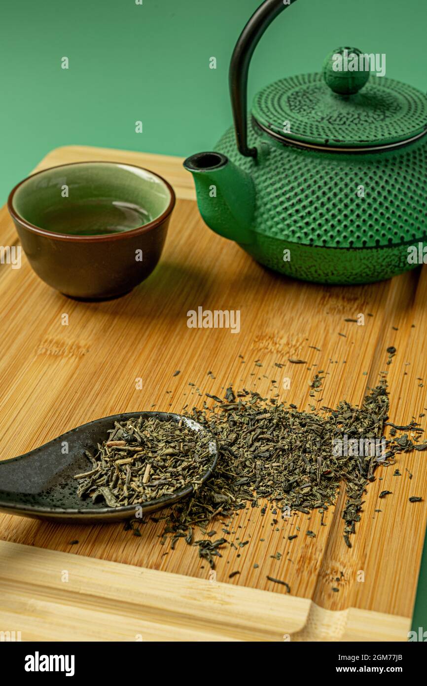 Traditional green cast iron teapot in Asian countries on bamboo table ...