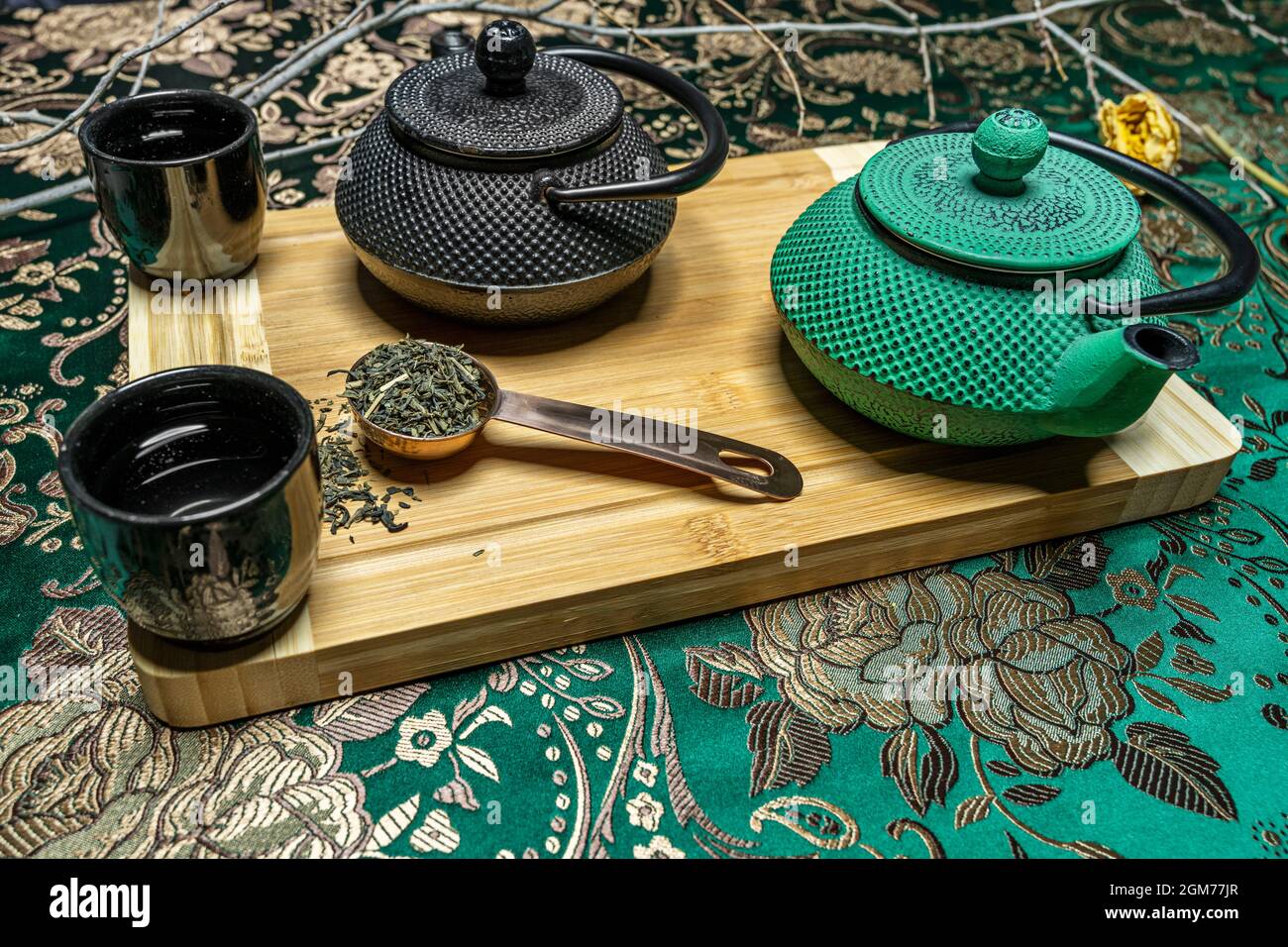 Asian tea service with two black and green cast iron teapots with ...