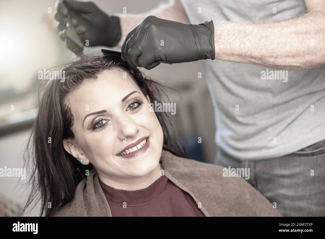 Hairdresser coloring client hair Stock Photo - Alamy