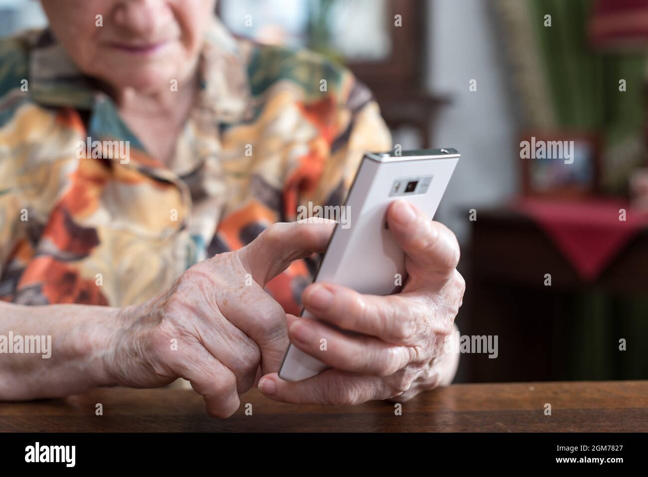 Old woman using smartphone at home Stock Photo - Alamy