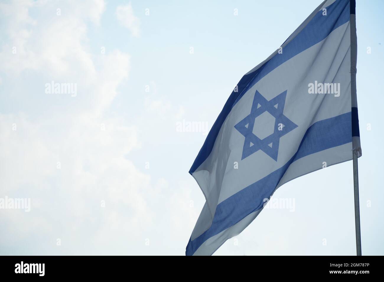 Israeli flag weaving in the wind against bright skies Stock Photo - Alamy