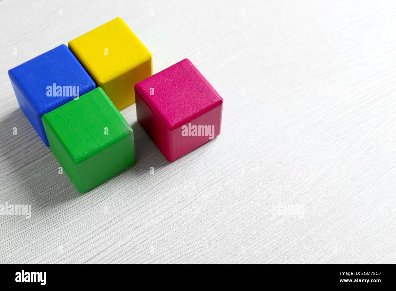 Color cubes on wooden background. Unity concept Stock Photo - Alamy