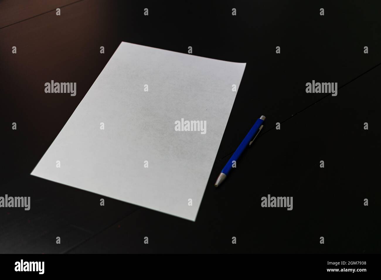 Blank bond paper and blue pen on a table Stock Photo - Alamy