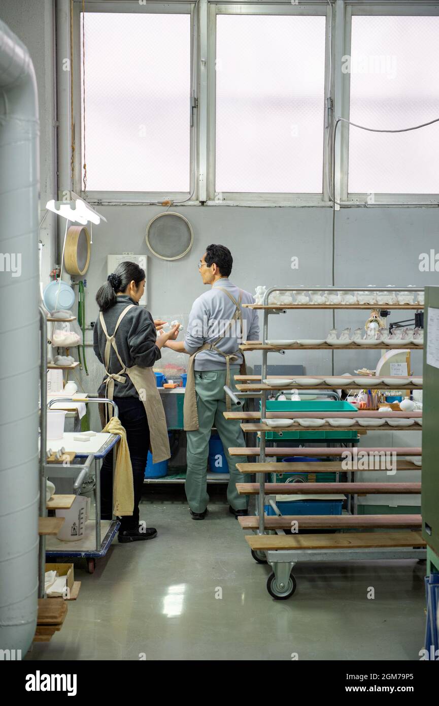 Employees of the pottery Craft Center at the work station. Noritake ...