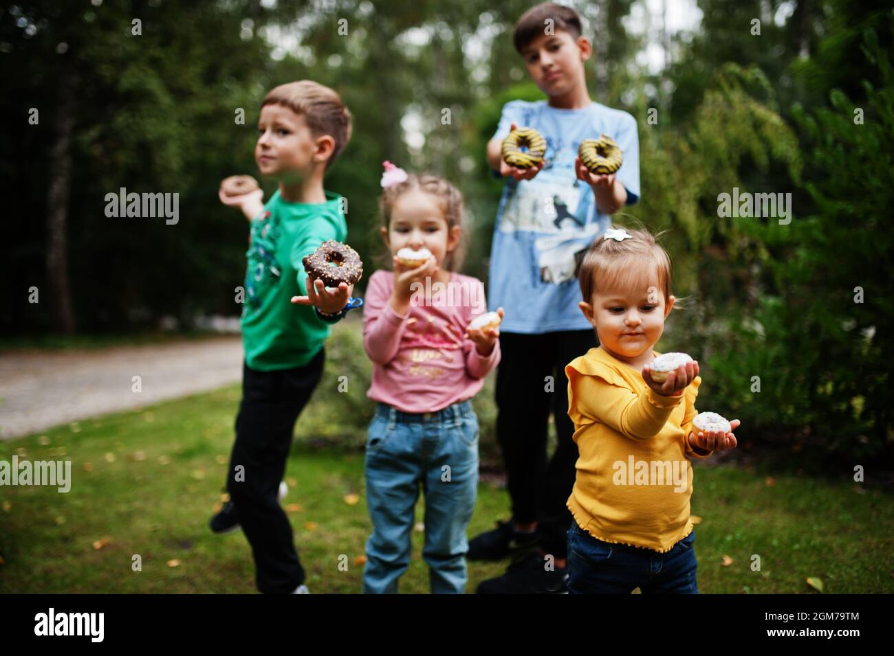 Four kids with doughnuts at evening yard. Tasty yummy donut food Stock ...